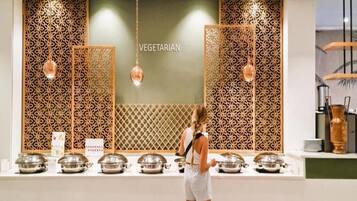 Uma área de buffet com uma placa que diz 'VEGETARIAN' e painéis decorativos.