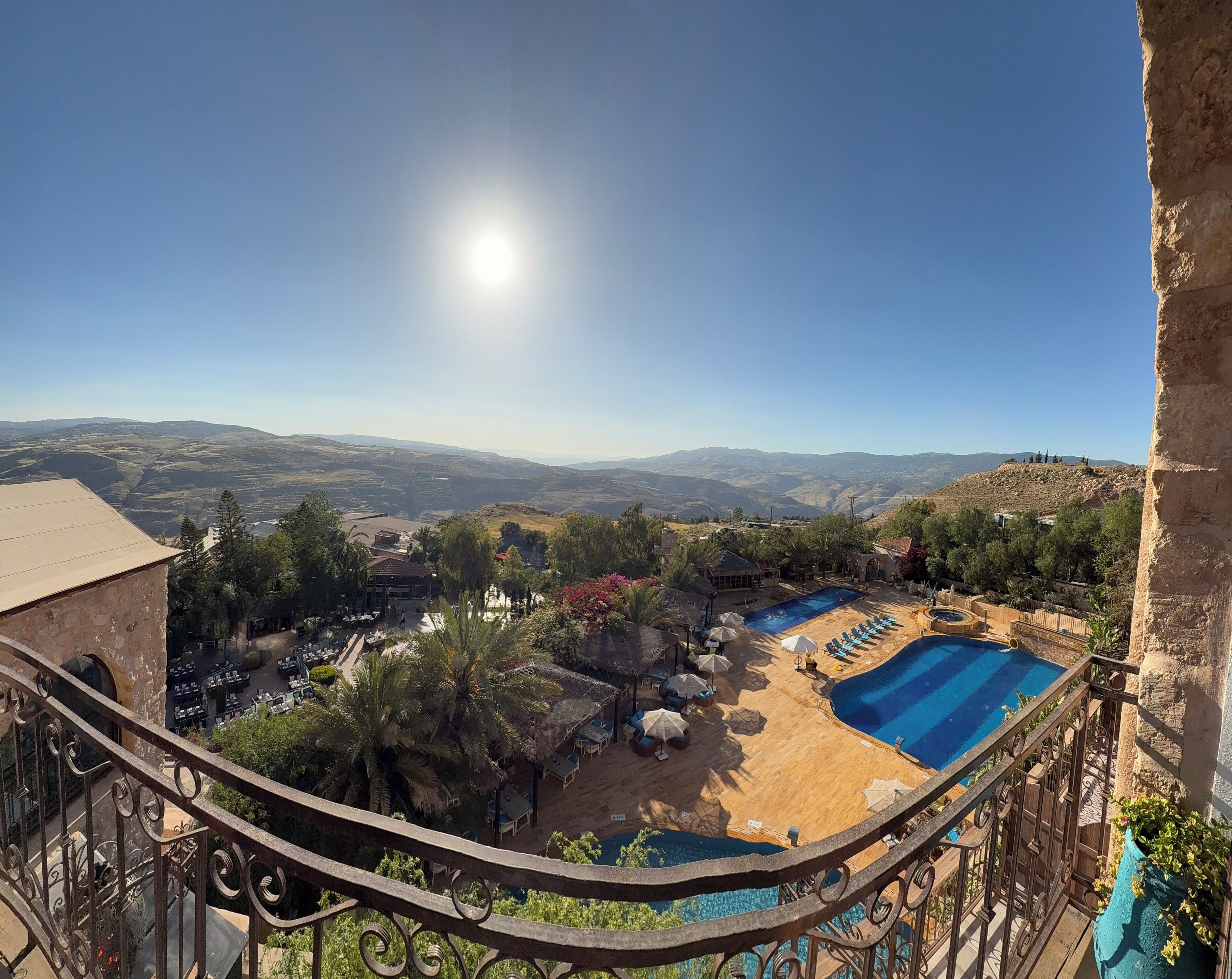 Um resort com várias piscinas, área de estar externa e vista panorâmica das montanhas.