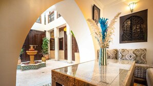 Um lobby com uma fonte, área de estar e vista para o pátio.