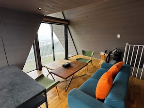Um interior moderno com uma mesa de jantar, cadeiras, um sofá e um rádio.
