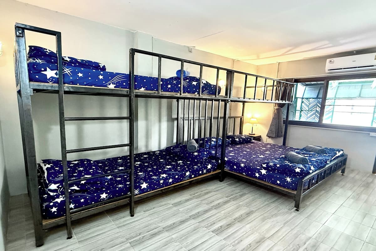 Quarto com beliche, edredom estampado com padrão de estrelas, janela com vista e ar-condicionado.