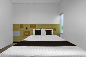 Quarto de hotel com uma cama, cabeceira com padrão geométrico, janela e painel de controle fixado na parede.