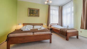 Quarto de hotel com duas camas, um quadro na parede e um candelabro.