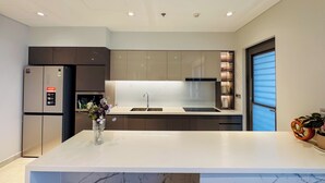 Uma cozinha moderna com bancada de mármore, eletrodomésticos de aço inoxidável e forno embutido.