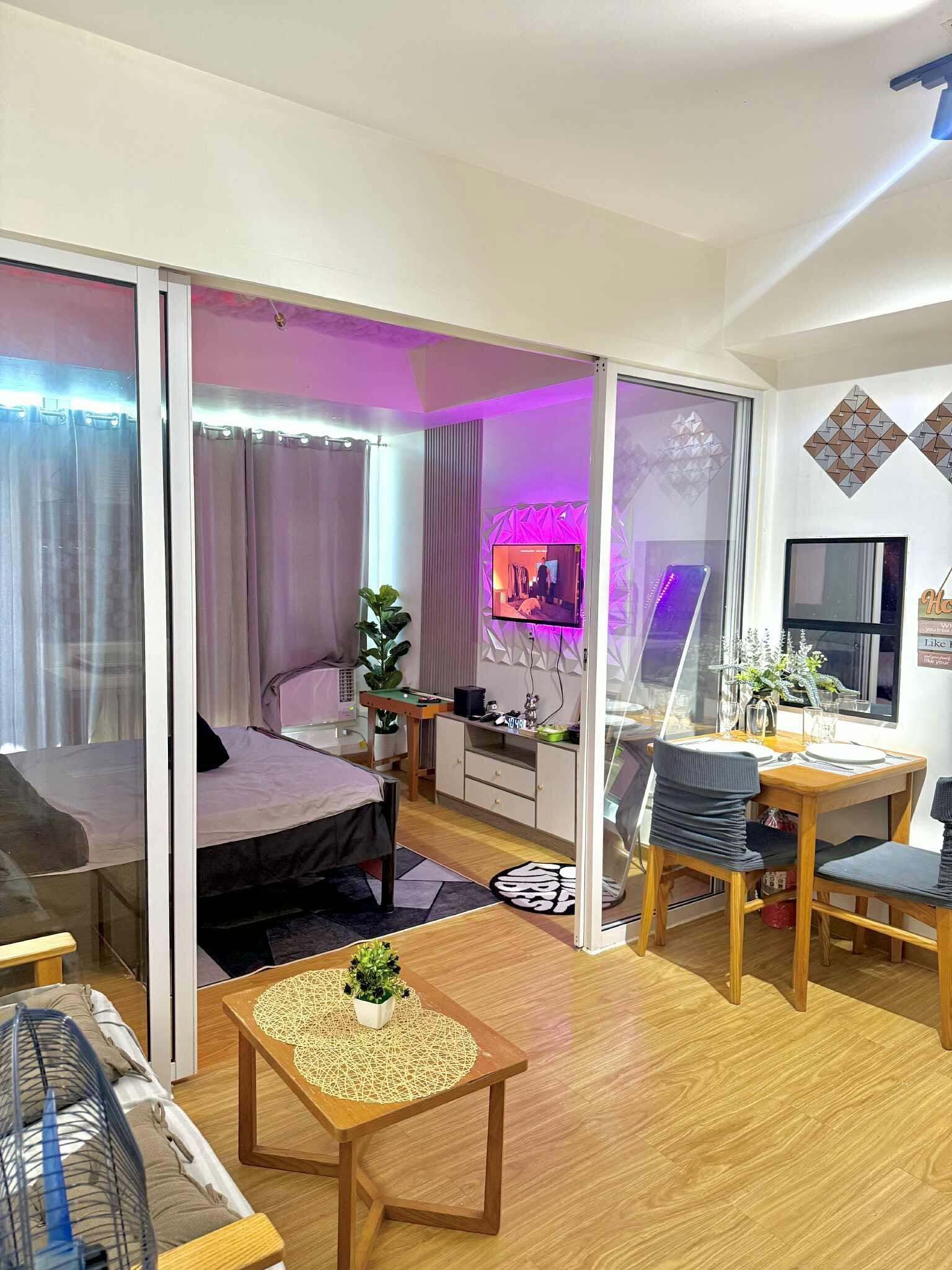 Quarto de hotel moderno com cama, escrivaninha, mesa de jantar e televisão.