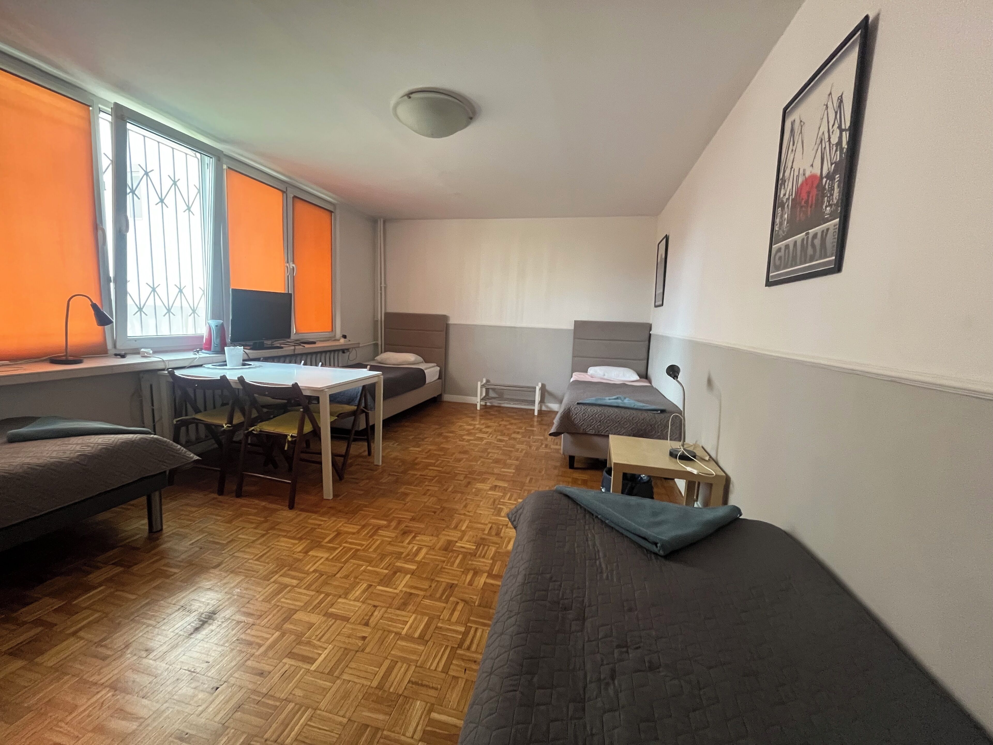 Quarto pequeno com cama, escrivaninha e cadeira.