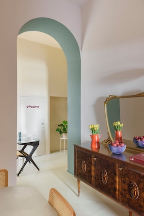 Um interior moderno com área de jantar, um armário com espelho e uma porta com a inscrição 'Paolina'.