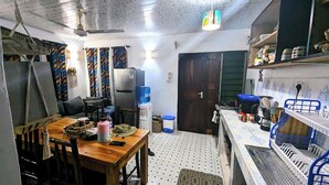 Cozinha compacta com área de jantar, bebedouro e geladeira.