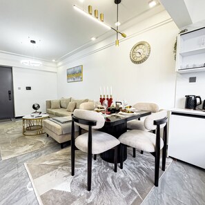 Uma sala de estar moderna com uma mesa de jantar, sofás e uma área de cozinha.