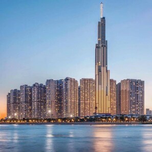 Um edifício alto com uma torre distintiva, cercado por outros edifícios residenciais altos.
