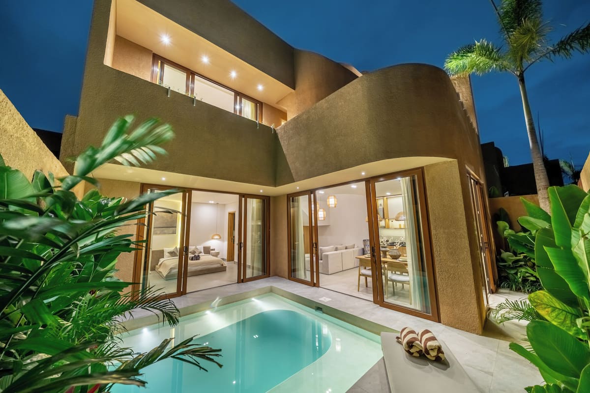 Uma casa moderna com piscina, grandes portas de vidro e área de jantar.