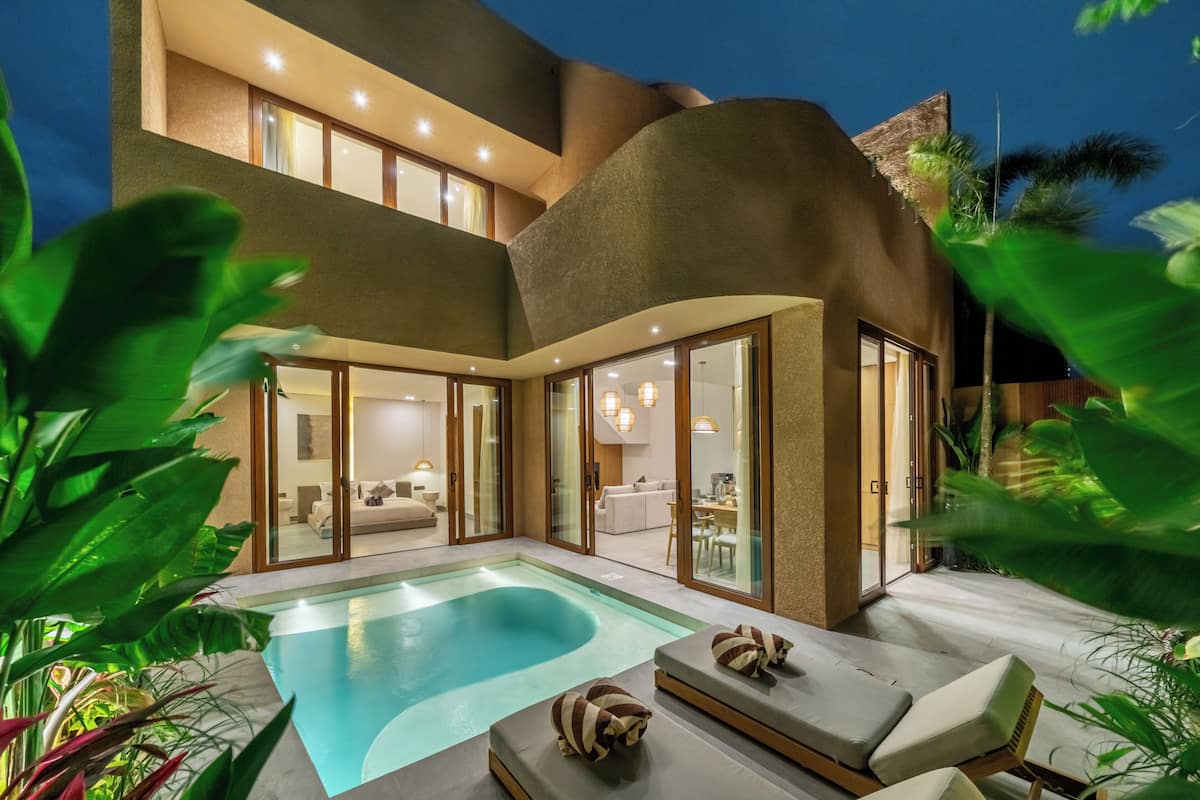 Uma casa moderna com piscina, área de estar externa e grandes janelas.
