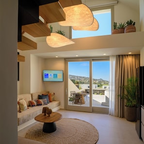 Uma sala de estar moderna com um sofá, uma mesa de centro e uma TV exibindo um aplicativo de previsão do tempo.