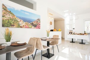 Uma área de refeições moderna, com uma grande pintura panorâmica, serviço de buffet e interior limpo e iluminado.