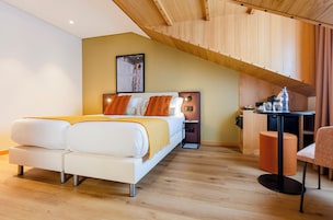Quarto moderno com cama, mesa de cabeceira e pequeno espaço de trabalho.