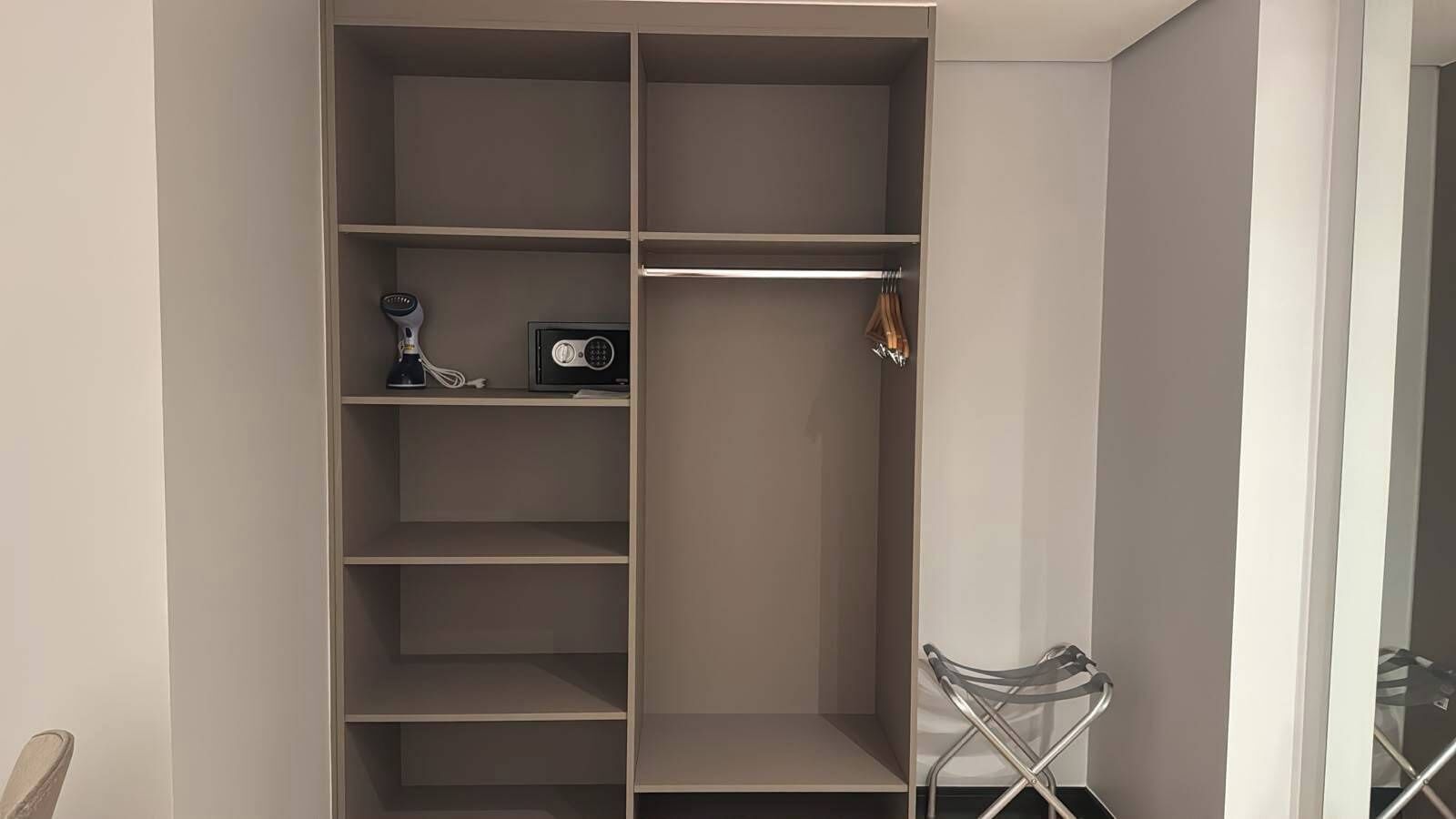 Um closet amplo com diversas prateleiras e espaço para pendurar roupas.
