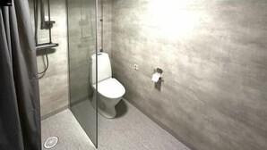 Um banheiro moderno com box de vidro, vaso sanitário e porta-toalhas.