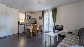 Espaço compacto com cozinha compacta, área de refeições e local para sentar.
