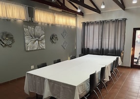 Uma sala de jantar com uma mesa comprida, cadeiras e decoração nas paredes.