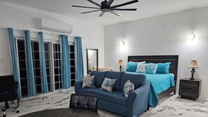 Um quarto com uma cama, um sofá, uma mesa de jantar e uma cadeira.