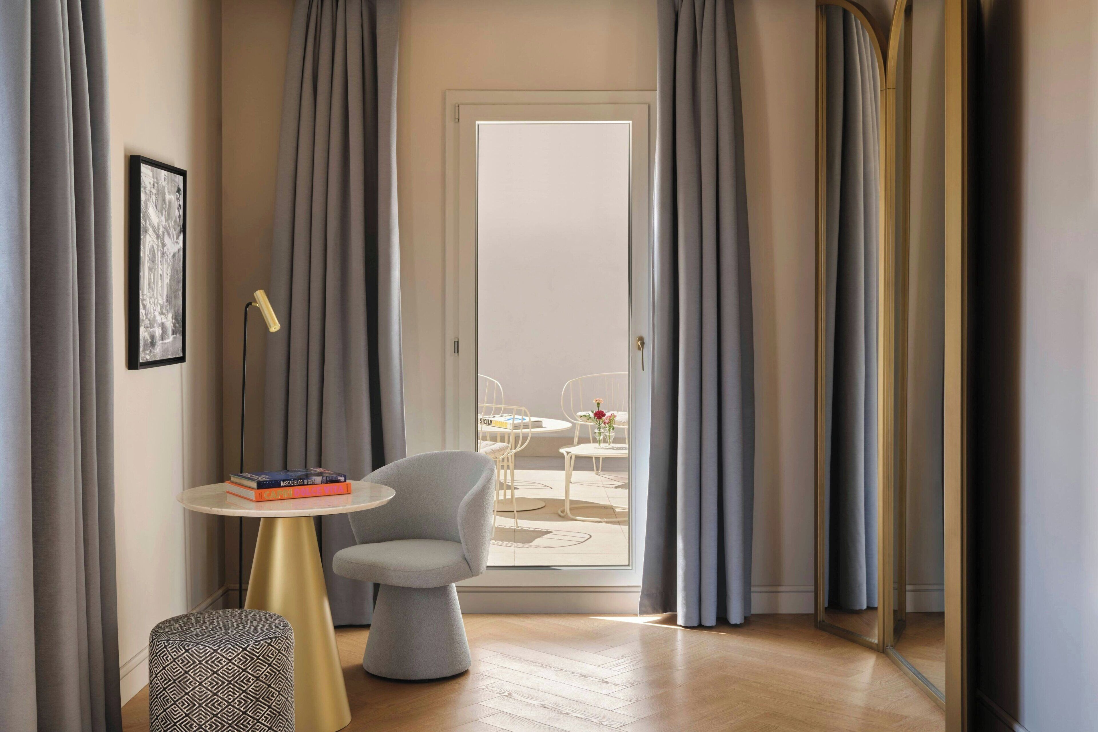 Quarto moderno com porta de vidro deslizante que dá para uma área externa com mobiliário.