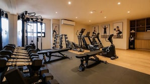 Uma academia com diversos equipamentos de exercício, incluindo esteiras, aparelhos de musculação e pesos livres.