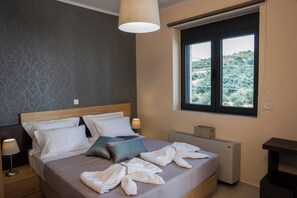 Quarto de hotel com cama, abajures, janela com vista e aquecedor.
