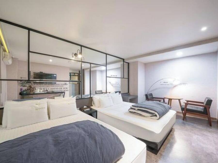 Quarto de hotel moderno com uma cama grande, uma escrivaninha e uma cadeira.