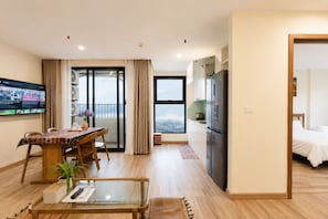 Apartamento moderno com área de jantar, cozinha e varanda com vista para a cidade.
