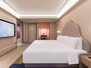 Quarto de hotel com uma cama grande, televisão de tela plana na parede, mesa de cabeceira e criado-mudo.