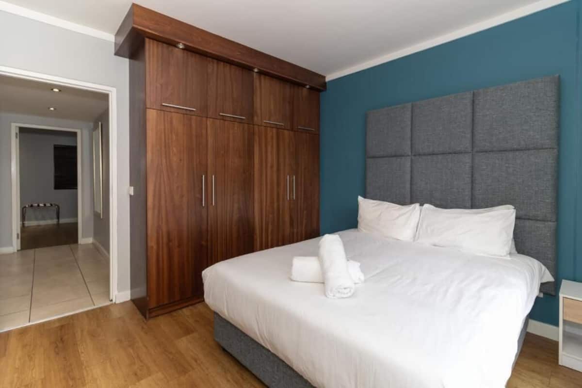 Quarto com cama, guarda-roupa e cabeceira.