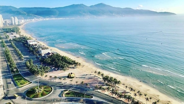 Paisagem costeira com praia, estradas e edifícios.