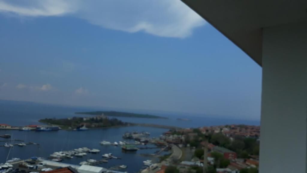 Uma cidade costeira com um porto, barcos e edifícios ao longo da orla.