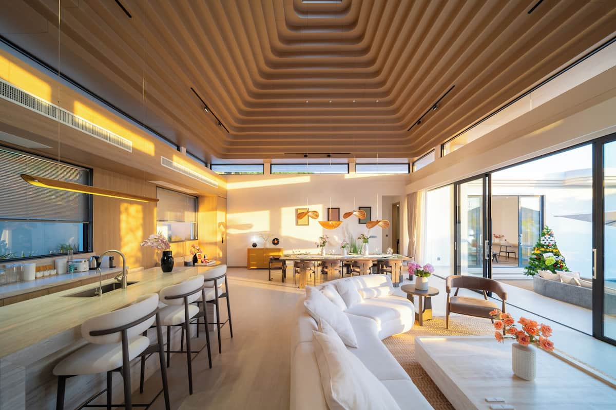 Um interior moderno com cozinha, sala de jantar e espaço para sentar.