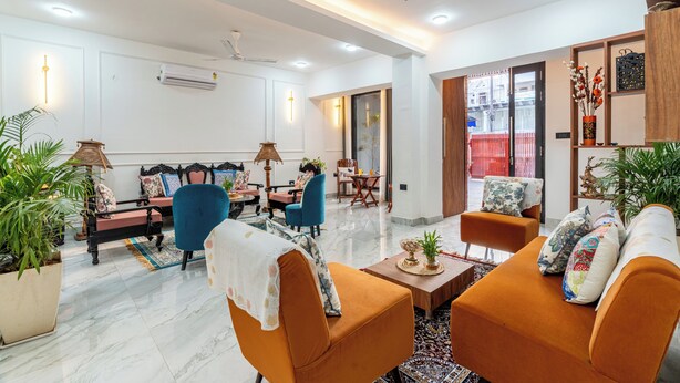 Uma sala de estar moderna com sofá, cadeiras, mesa de centro e área de jantar.
