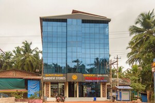 Um edifício de vários andares com letreiros comerciais para 'SHRIDEVI STORES' e 'SHRIDEVI RESIDENCY'.