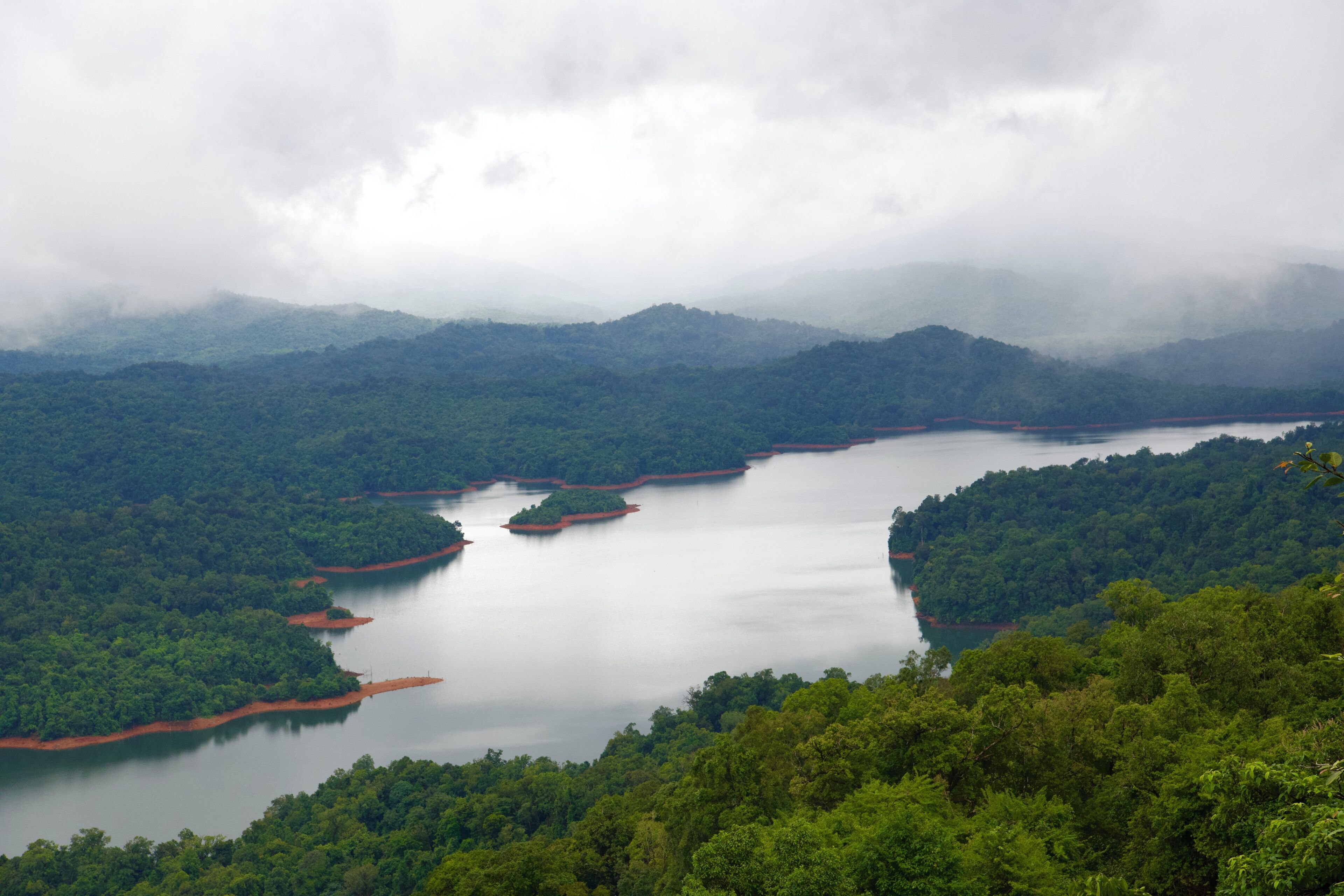 Um lago rodeado por colinas arborizadas.