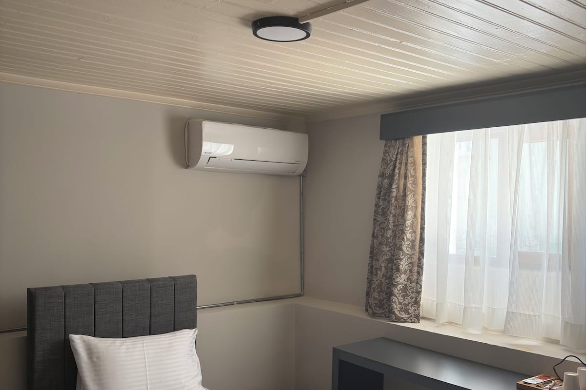 Quarto solteiro standard | Cofres nos quartos, espaço de trabalho para notebook, cortinas blackout