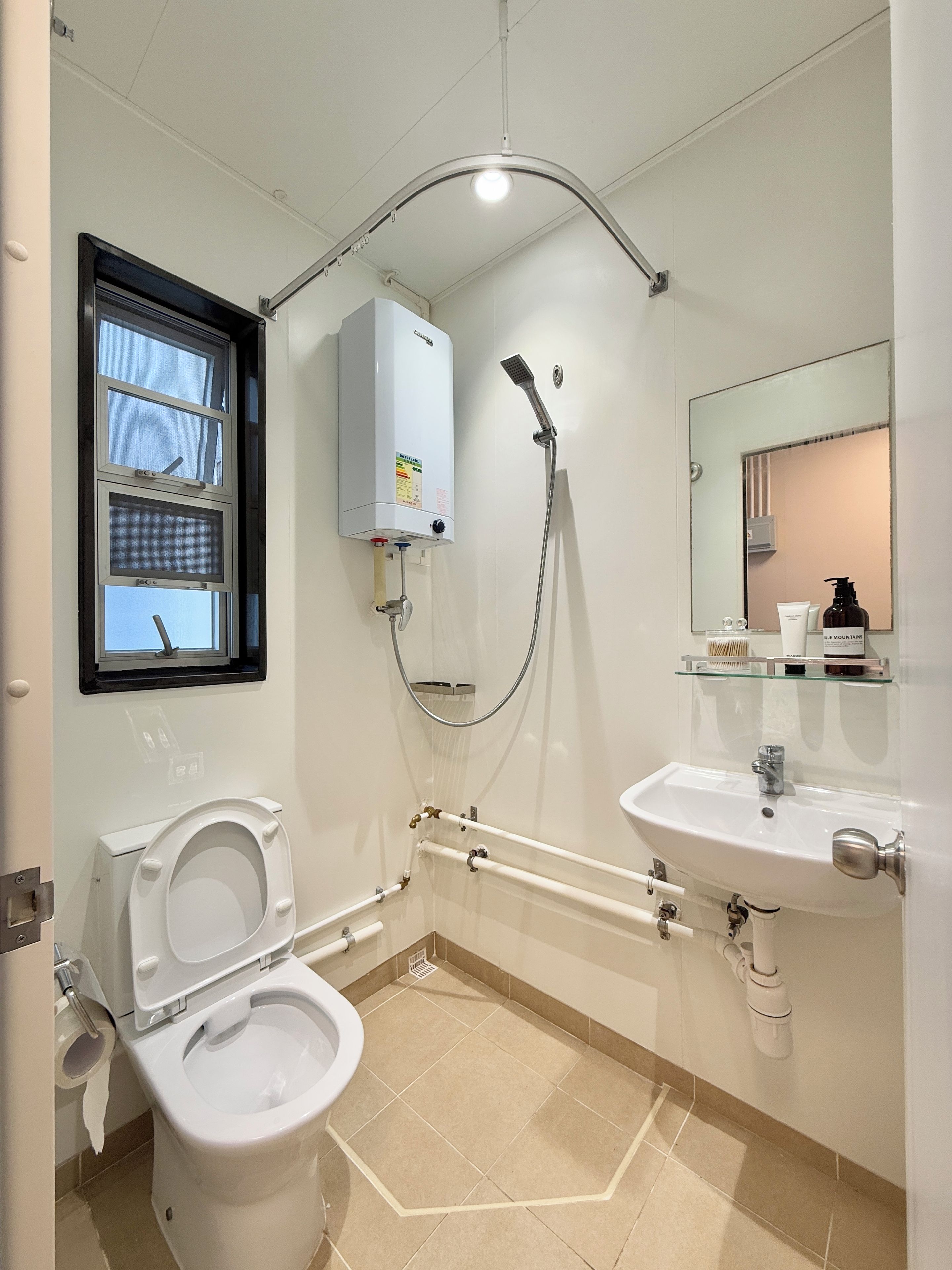 Casa de banho moderna com sanita, bidé, chuveiro e lavatório.