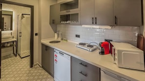 Cozinha moderna equipada com lava-louças, micro-ondas e fogão compacto.