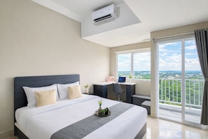 Quarto de hotel moderno com uma cama grande, uma escrivaninha e vista para a cidade.