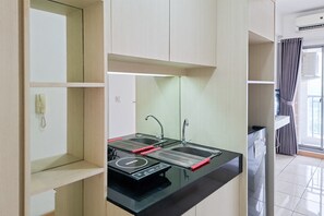 Cozinha moderna com bancada preta, pia de aço inoxidável e fogão por indução embutido.