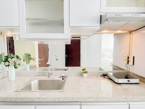 Uma cozinha moderna com uma pia de aço inoxidável, forno embutido e micro-ondas.
