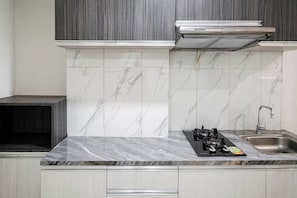 Uma cozinha moderna com fogão a gás, pia de aço inoxidável e coifa Modena.