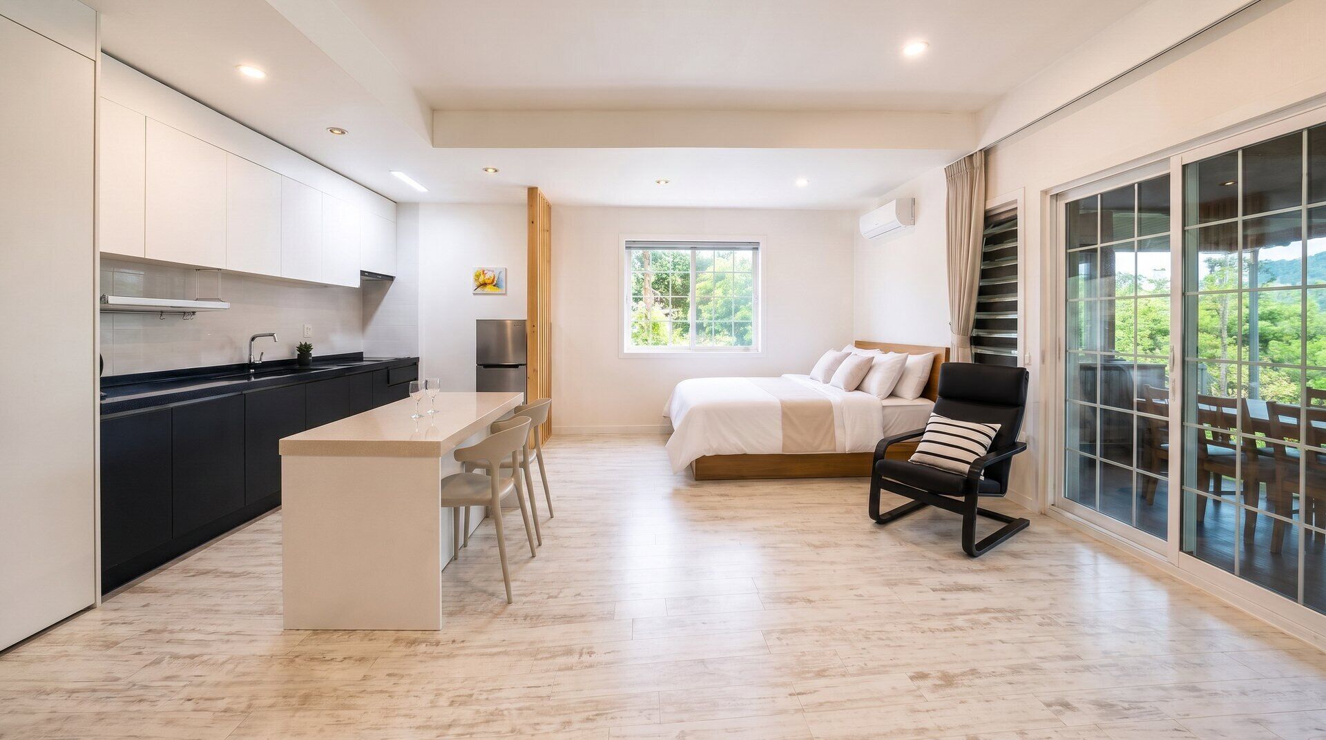 Interior moderno com cozinha, sala de jantar e quarto com uma janela grande.