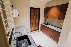 Uma cozinha compacta com pia, bancada, armários de madeira e uma porta.