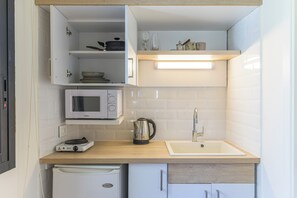 Estúdio luxo, 1 cama de casal, cozinha americana, vista para a cidade | Cozinha americana privada | Frigobar, micro-ondas, cooktop, chaleira elétrica