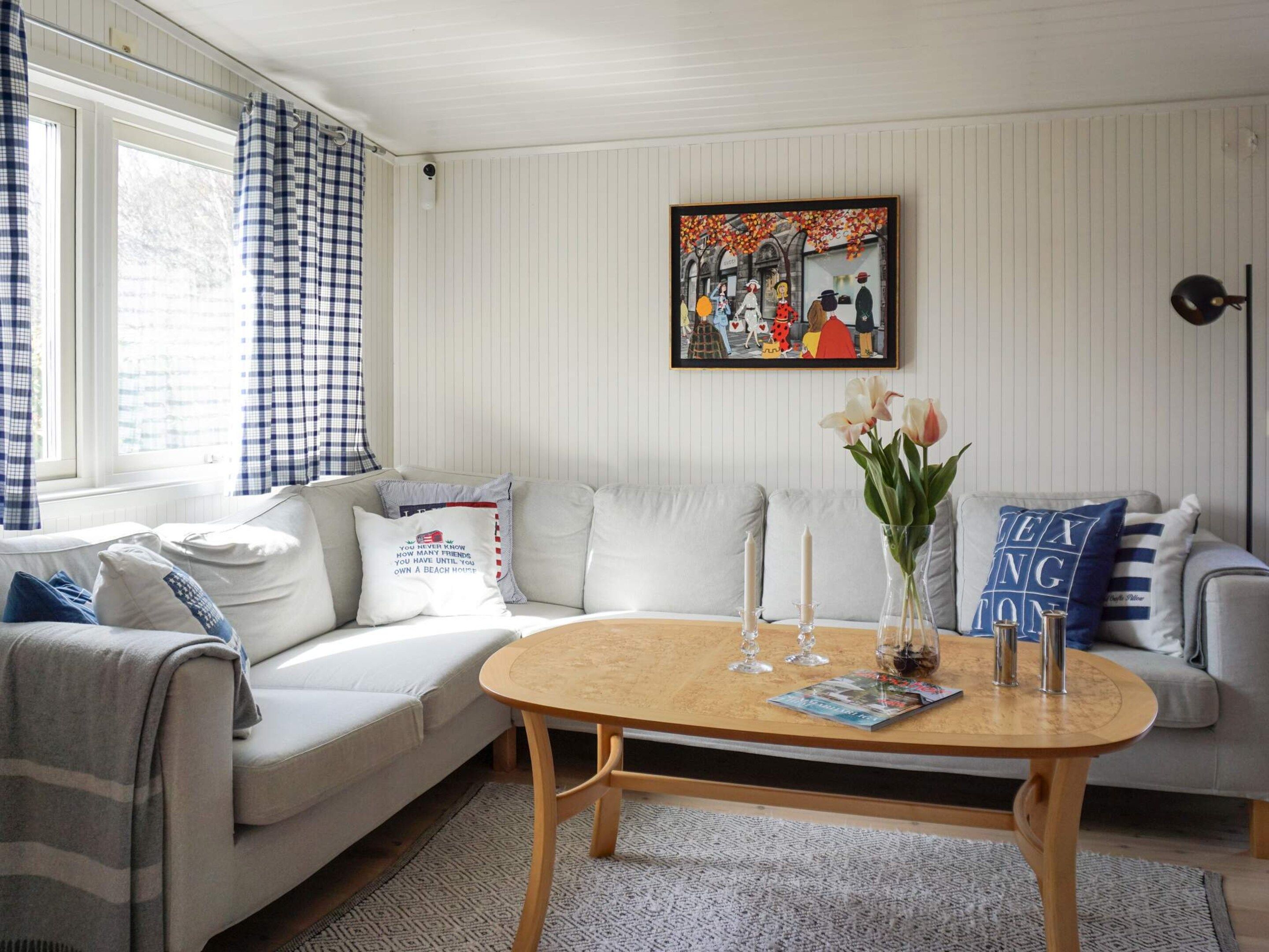 Sala de estar com sofá, mesa de centro e um quadro na parede.