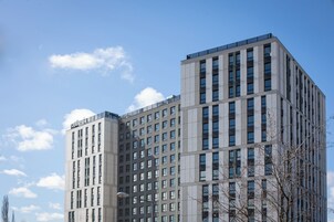 Um edifício de vários andares com uma fachada de janelas em grade e telhado plano.
