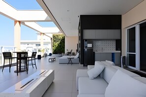 Uma sala de estar moderna com sofá, cadeiras, mesa de jantar e cozinha.